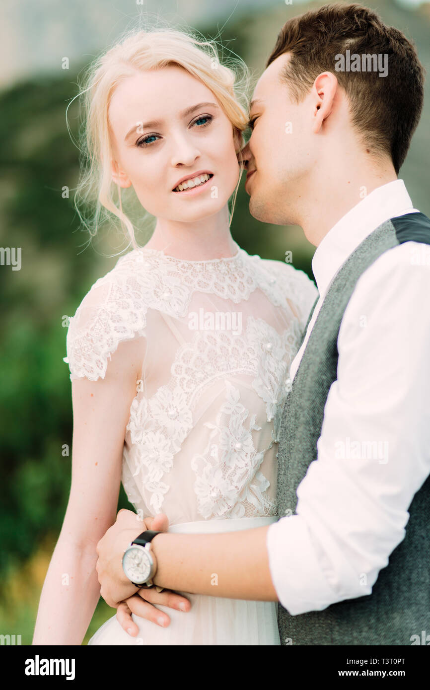 Beautiful bride and groom hug each other tender standing on the golden ...