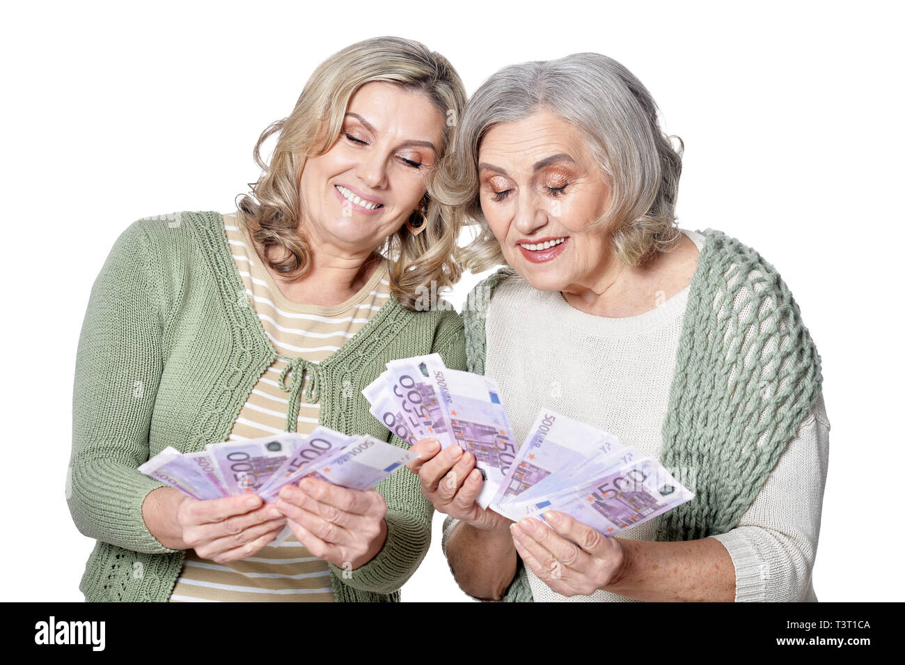 Portrait of two smiling women with money bills isolated on white ...