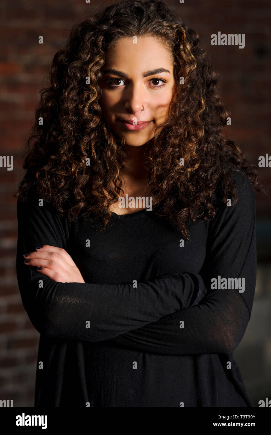 Mixed race woman standing with arms crossed Stock Photo - Alamy