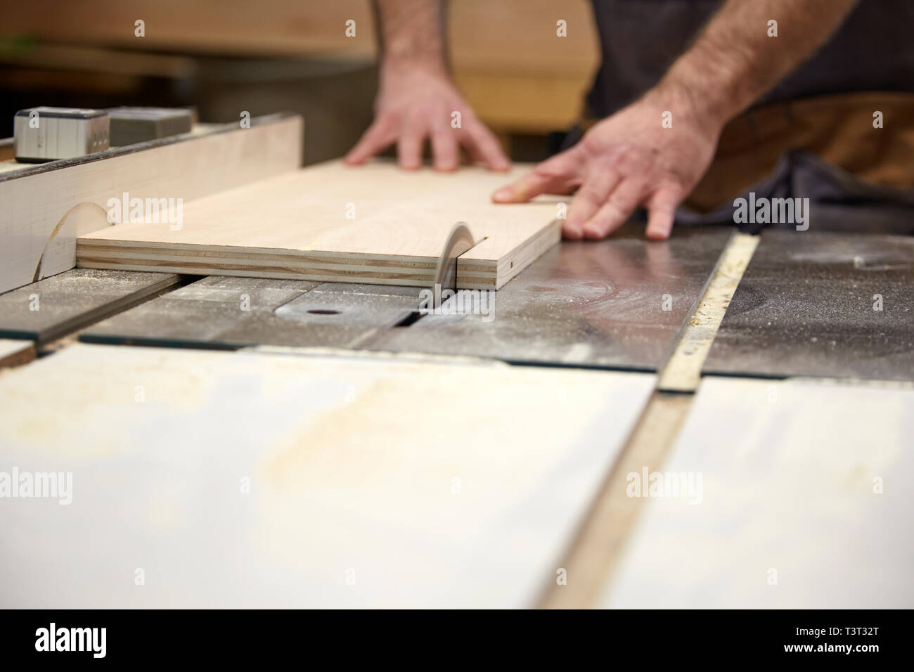 Carpenter using table saw in workshop Stock Photo - Alamy