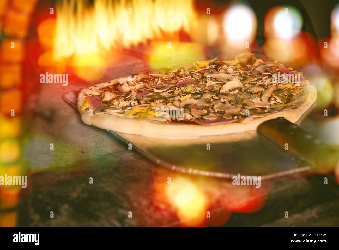 Fresh original Italian pizza on a shovel is putting in a traditional ...