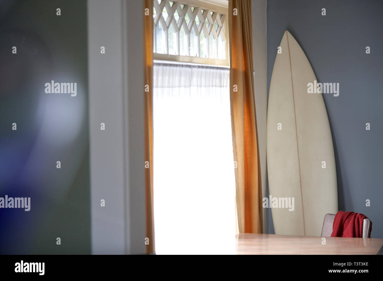 Surfboard and table at window Stock Photo - Alamy