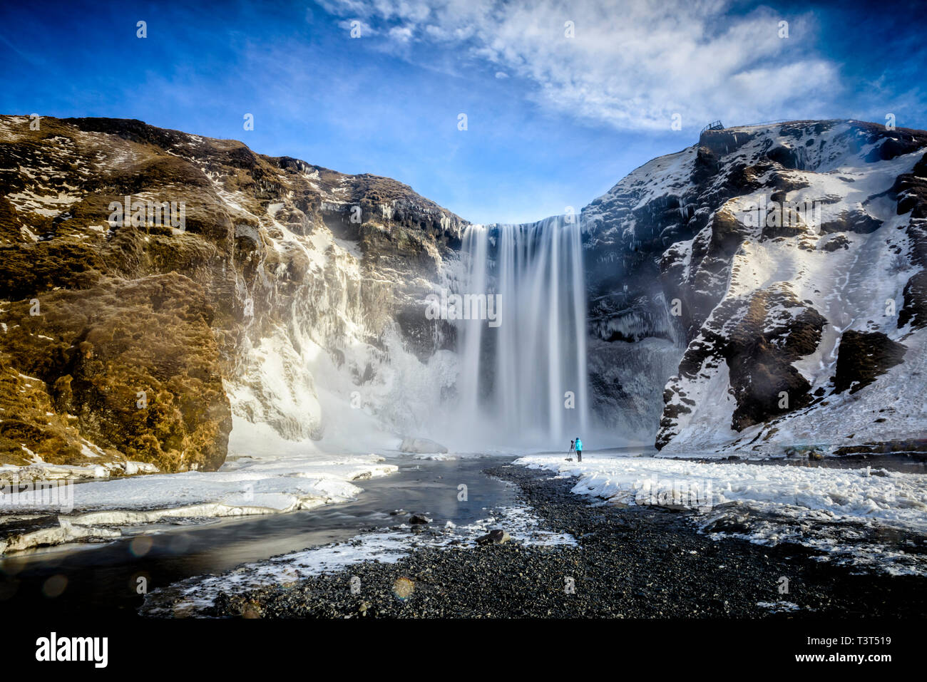 Waterfall pouring over icy cliffs in remote landscape Stock Photo - Alamy