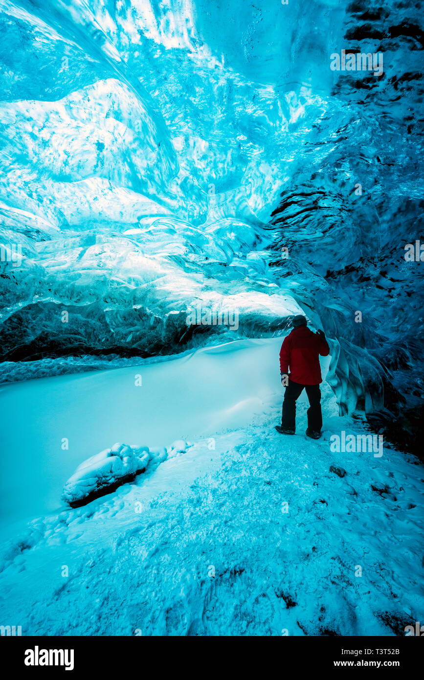Hiker walking in ice cave Stock Photo - Alamy