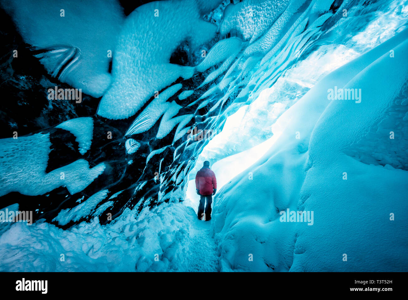 Hiker walking in ice cave Stock Photo - Alamy