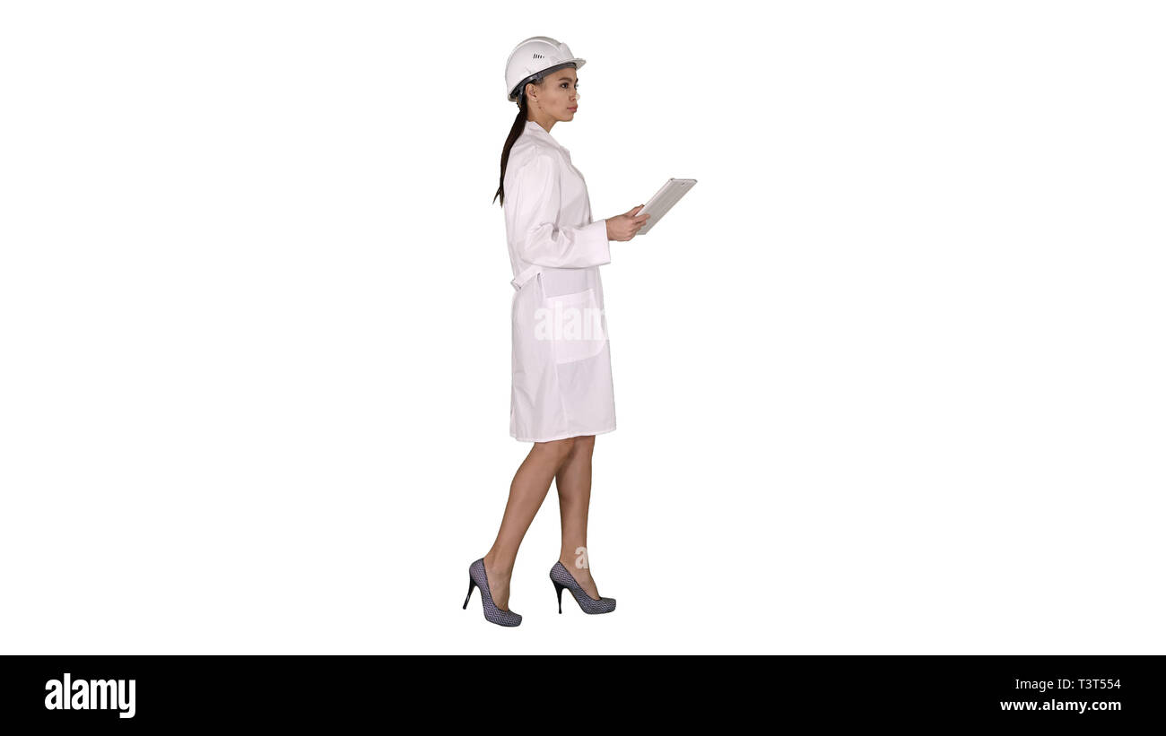 Young woman engineer walking with tablet looking at objects around on ...