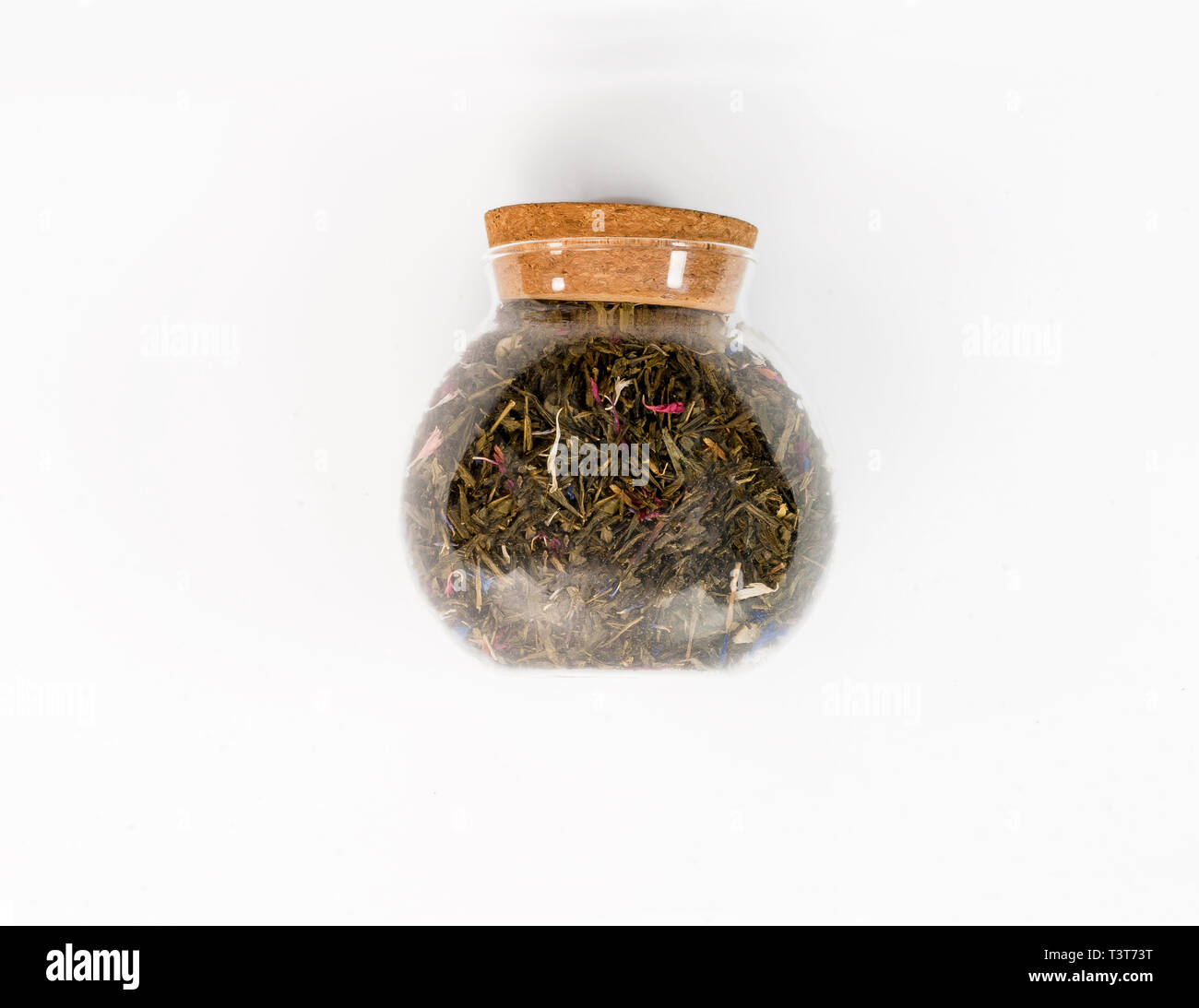 Round glass jar with a cork filled with aromatic tea with dried flowers ...