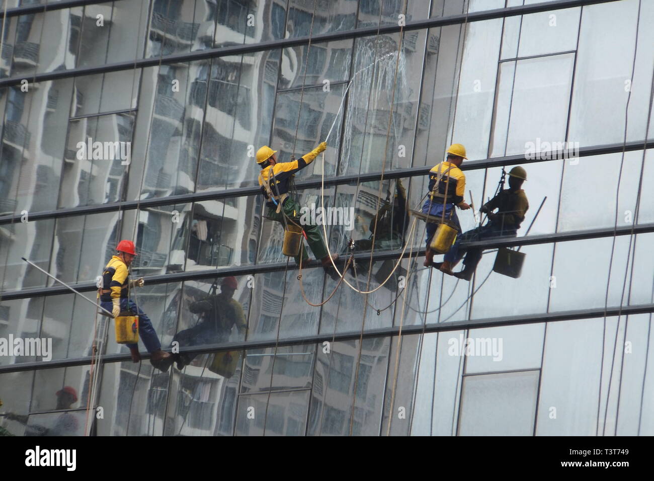 Workers clean the glass facade of a skyscraper in shenzhen, China Stock ...