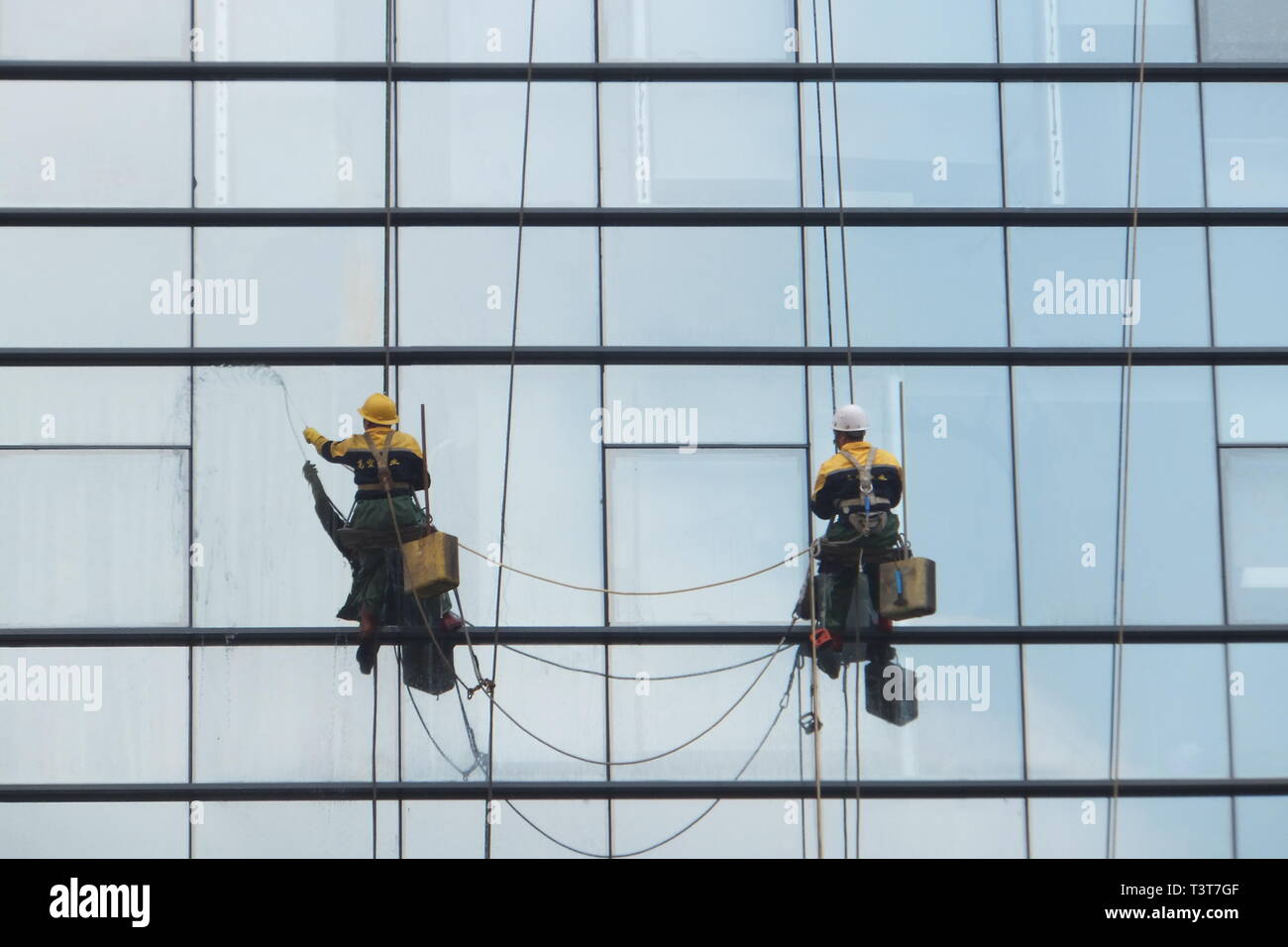 Workers clean the glass facade of a skyscraper in shenzhen, China Stock ...