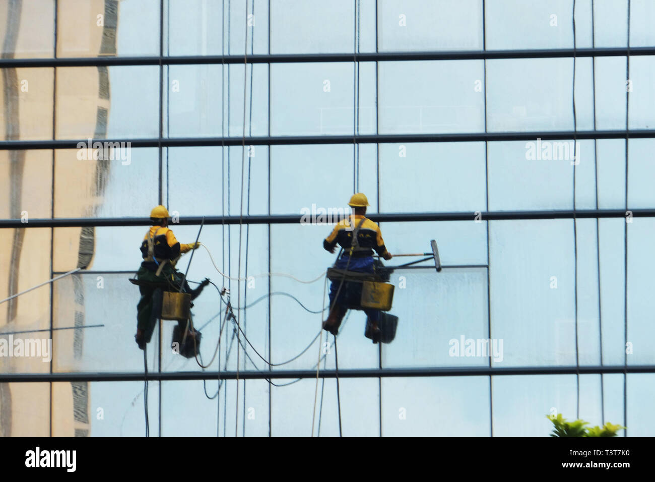 Workers clean the glass facade of a skyscraper in shenzhen, China Stock ...