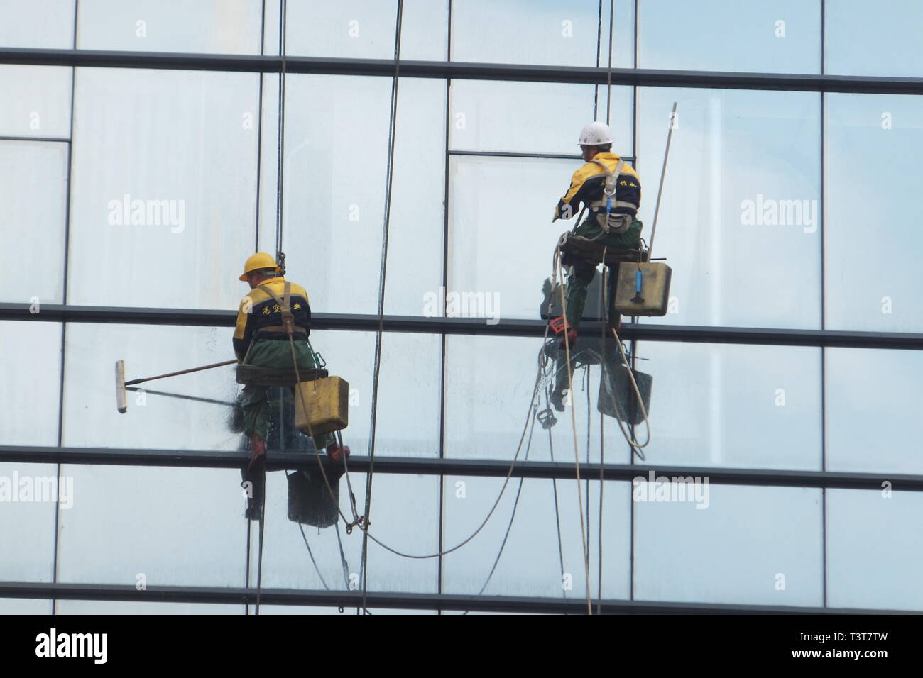 Workers clean the glass facade of a skyscraper in shenzhen, China Stock ...
