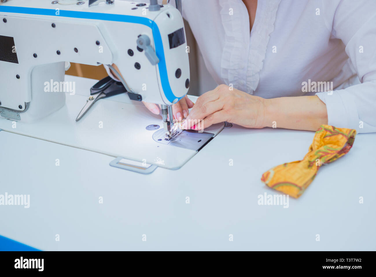 Professional tailor sewing clothes with sewing machine at atelier Stock ...