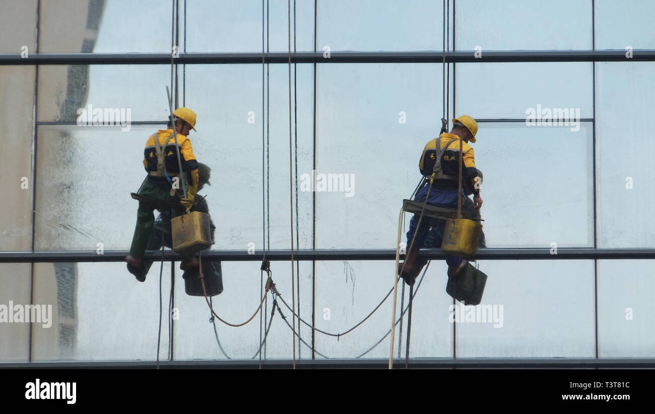 Workers clean the glass facade of a skyscraper in shenzhen, China Stock ...