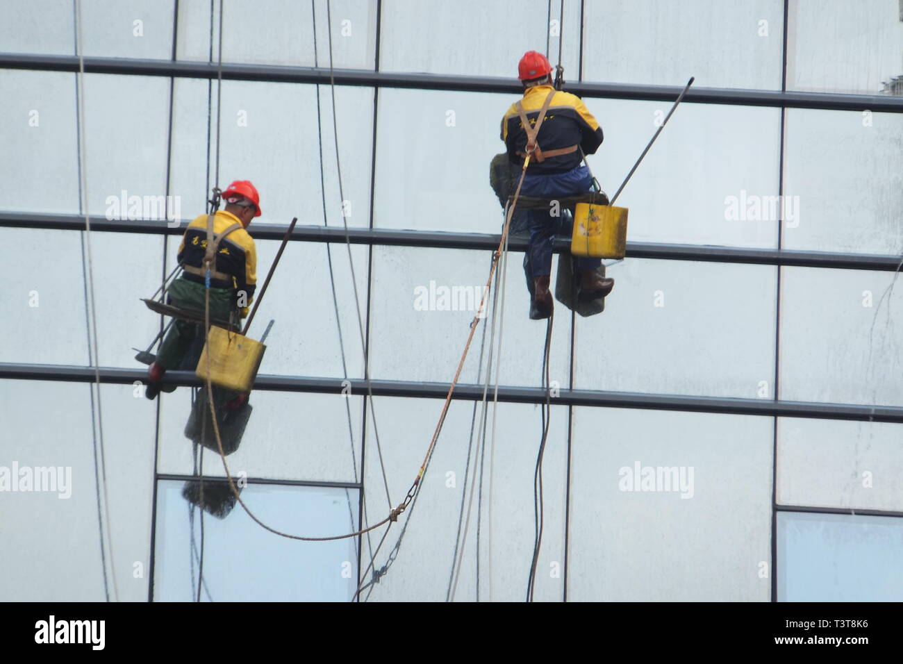 Workers clean the glass facade of a skyscraper in shenzhen, China Stock ...