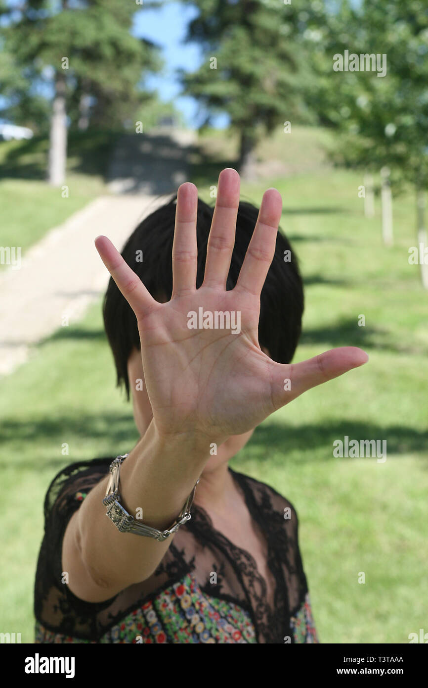 Beautiful dark haired girl on a bright sunny day in the park making ...