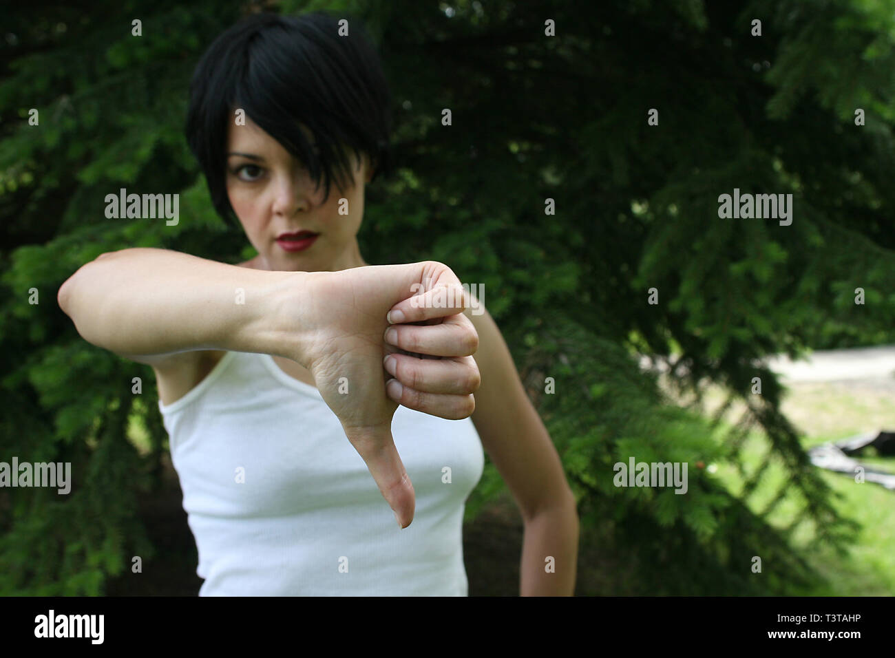 Beautiful dark haired lady with a white top making hand signals. Two ...