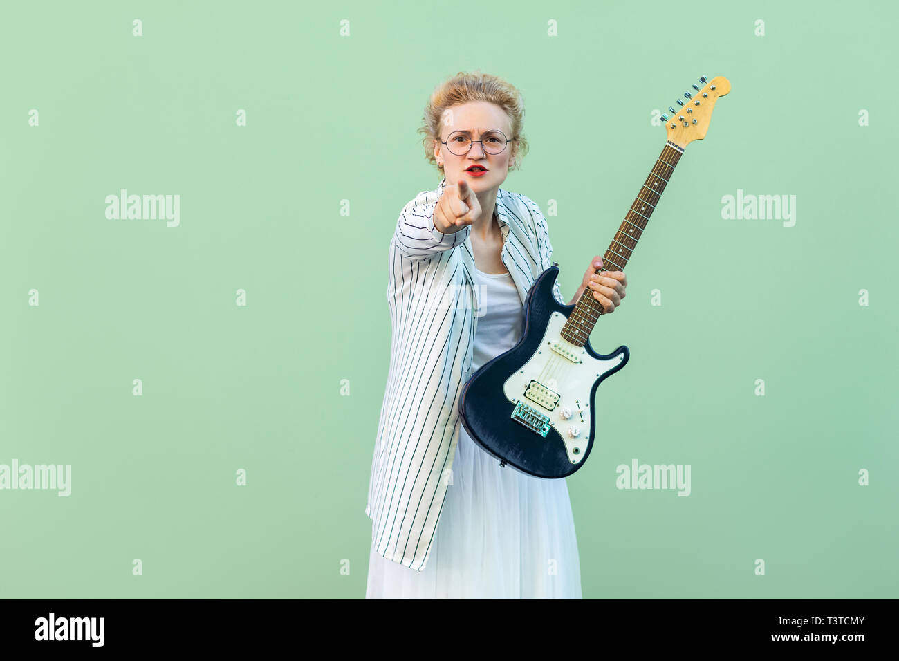 Hey you. Portrait of serious young blonde woman in white striped blouse ...