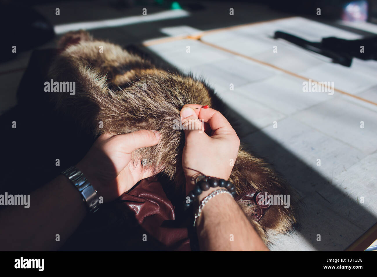 Professional tailor, designer repairing fur coat at atelier, studio ...