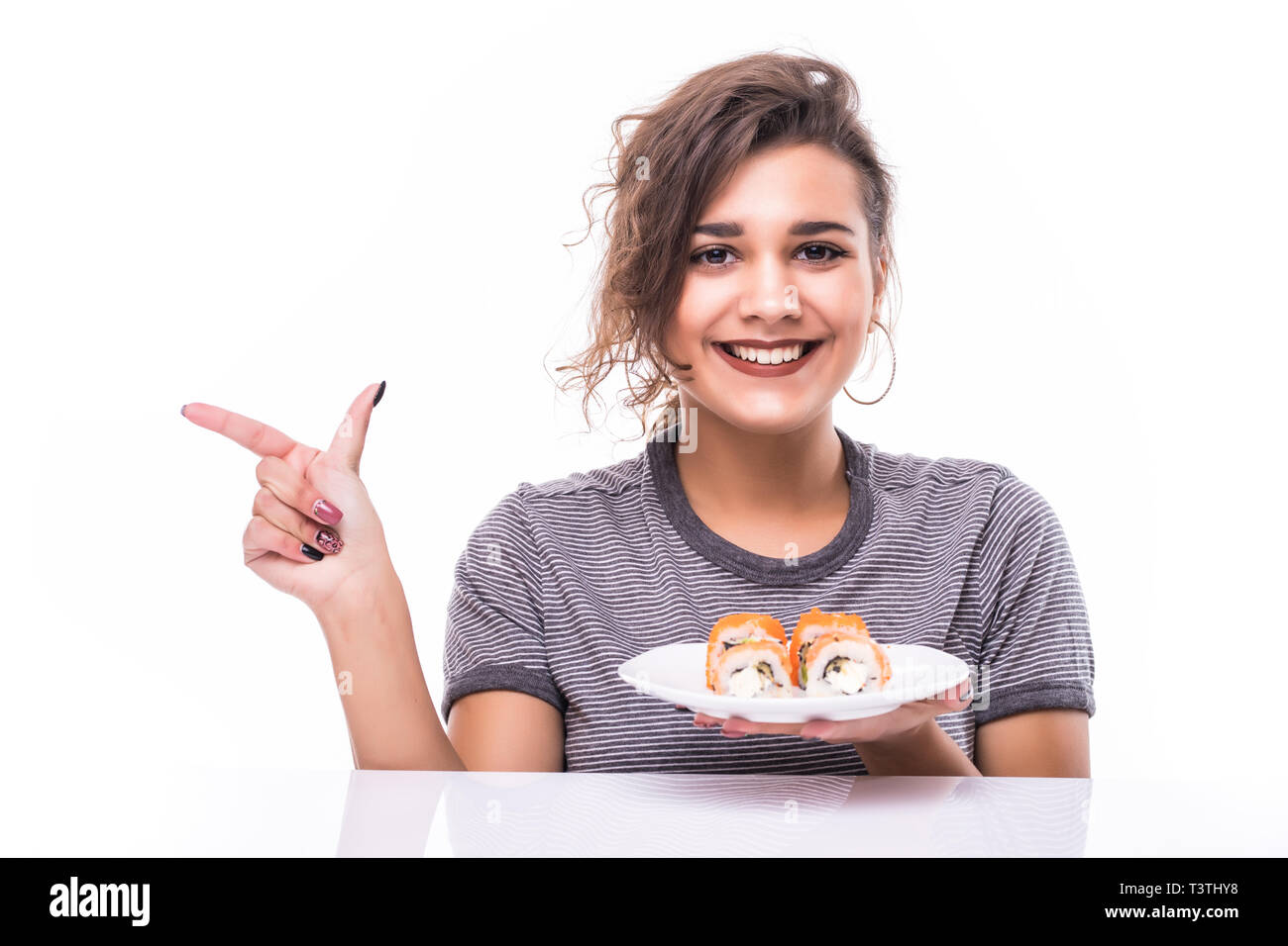 Young woman holding asian chopsticks pointing and showingto the side ...