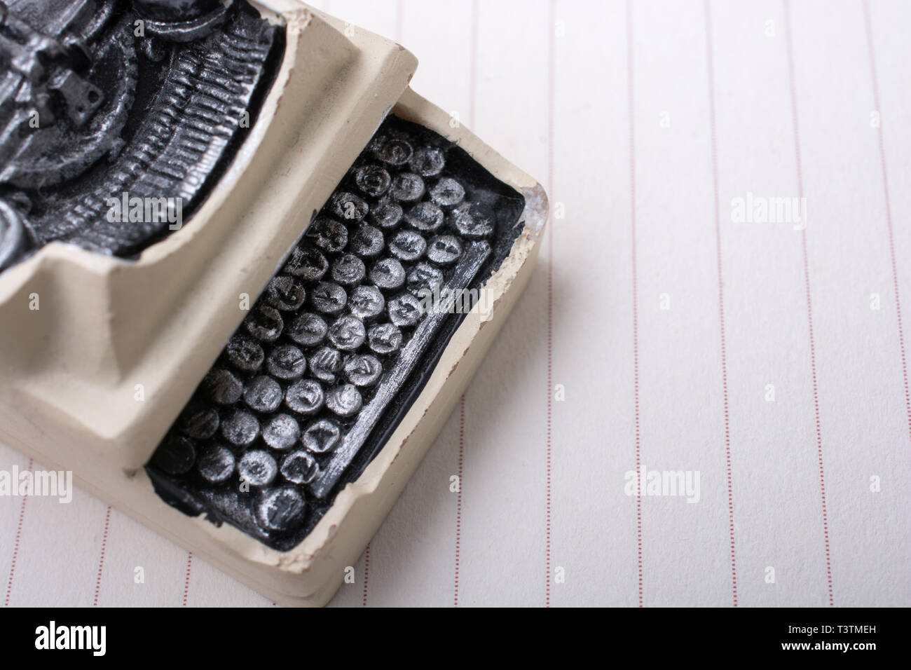 Retro syled tiny typewriter model on a paper background Stock Photo - Alamy