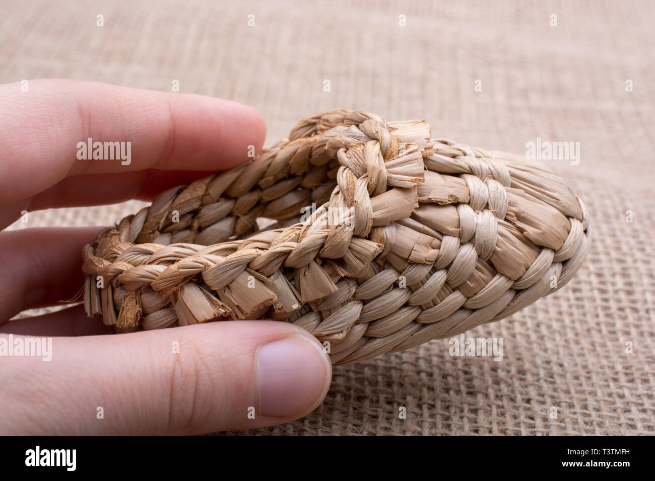 Pair of brown color straw shoes hand on a brown background Stock Photo ...