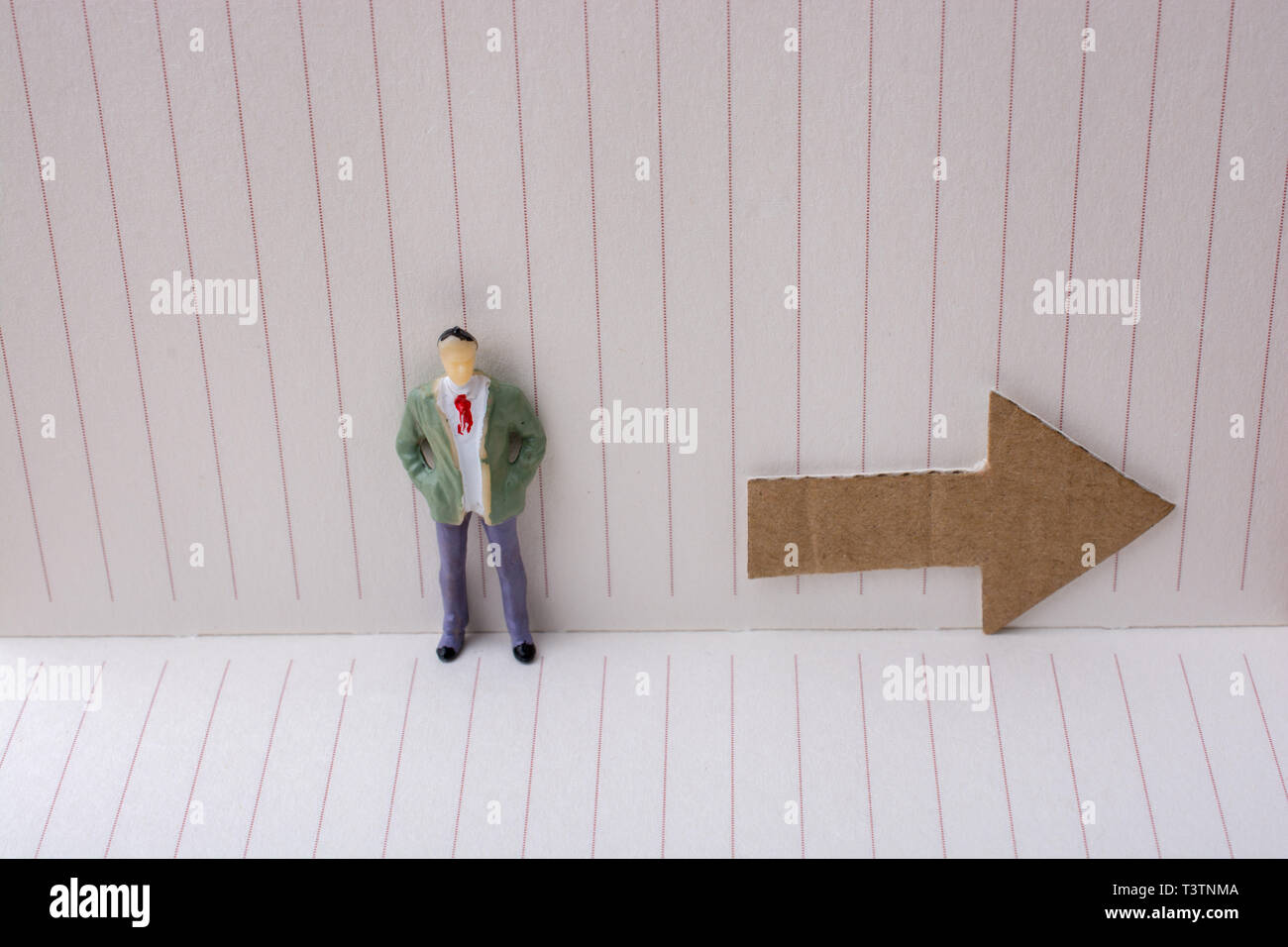 Figurine and an paper arrow in a notebook on canvas Stock Photo - Alamy