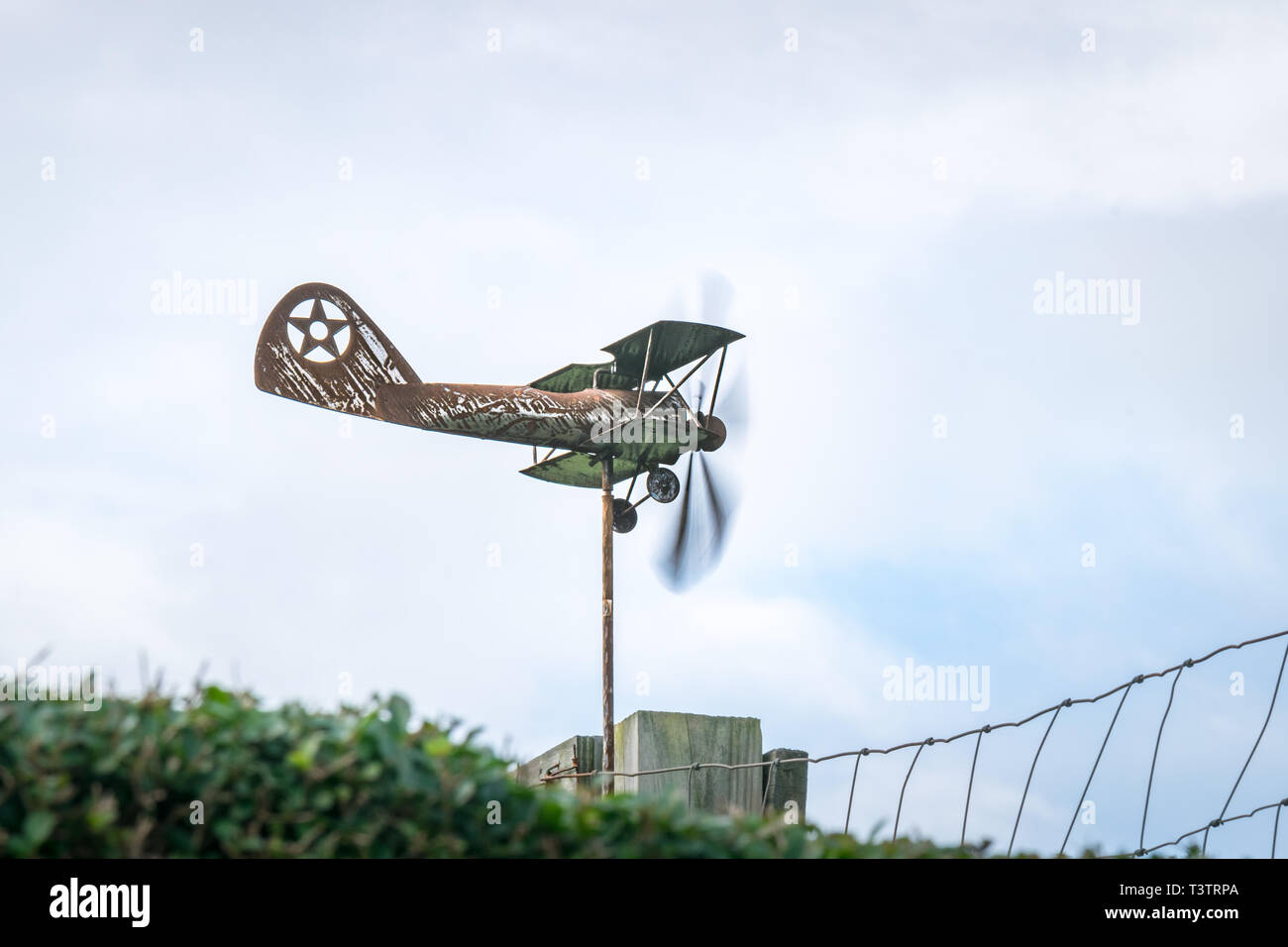 Weather vane in form of an old rusty biplane at a side-view, with ...