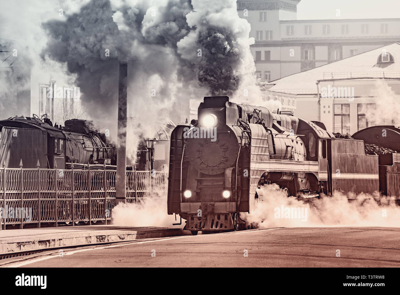Steam train departs from the railway station Stock Photo - Alamy