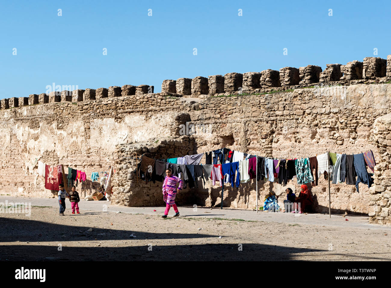 Women waiting for their laundry to get dry by the Medina walls in ...