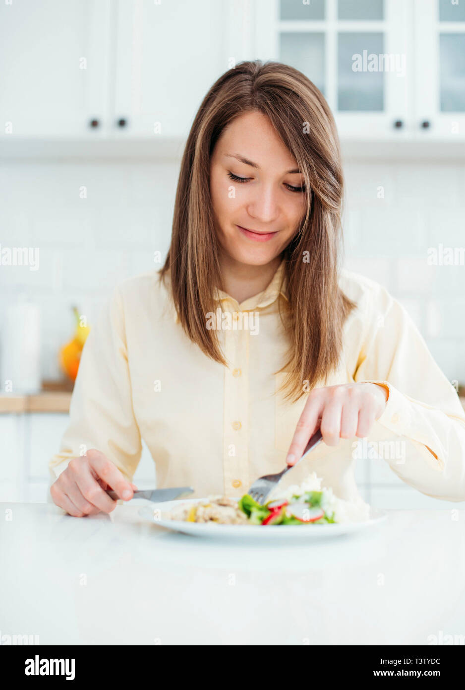 Young woman eating healthy food having lunch meal at home Stock Photo ...