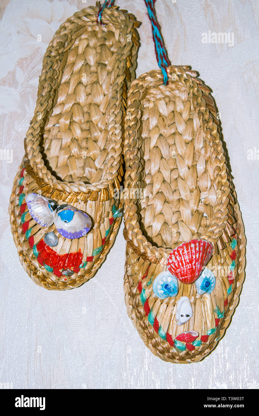 Design slippers of straw with a face made of shells Stock Photo - Alamy