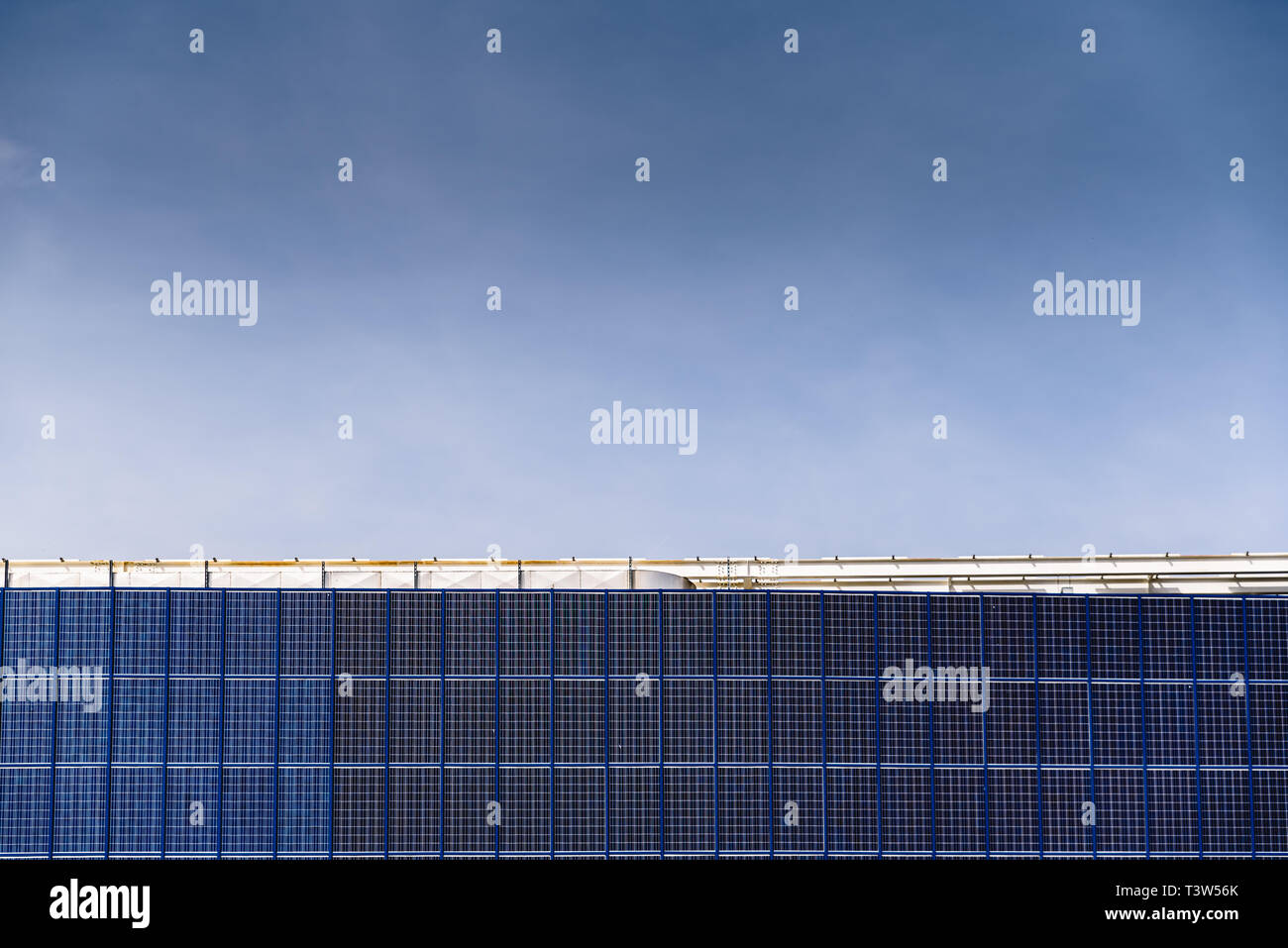 Facade of building covered with solar panels to convert the sun into ...