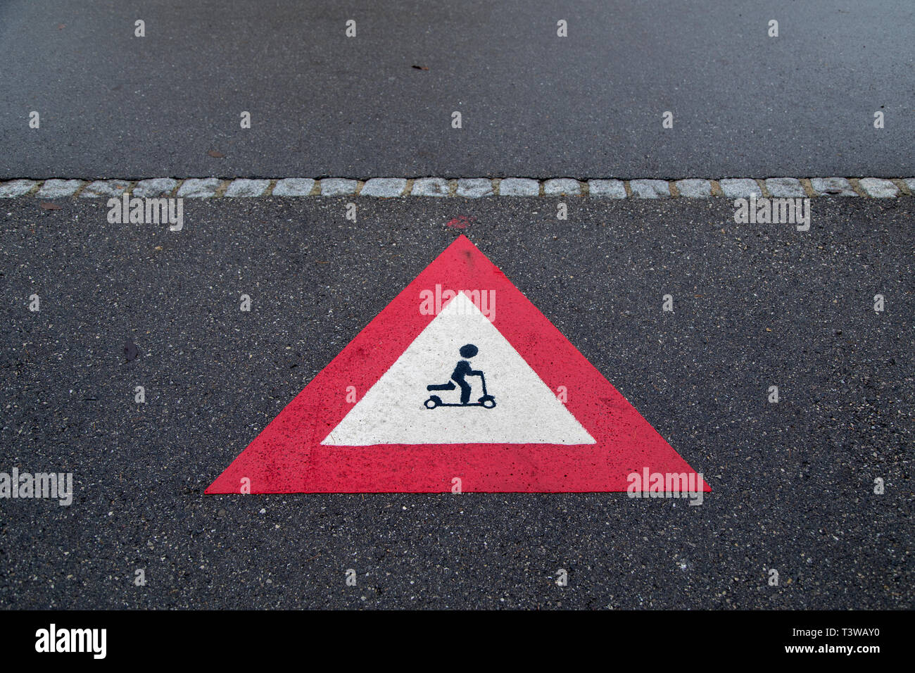 A warning sign on the pavement warns of children on kick bikes Stock ...