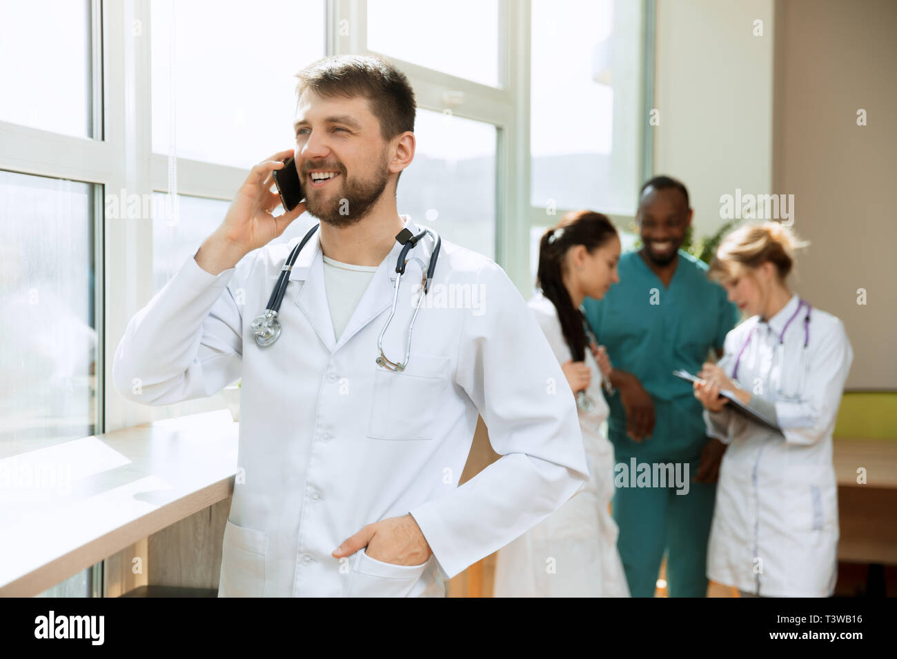 Healthcare people group. Professional caucasian male doctor with phone ...