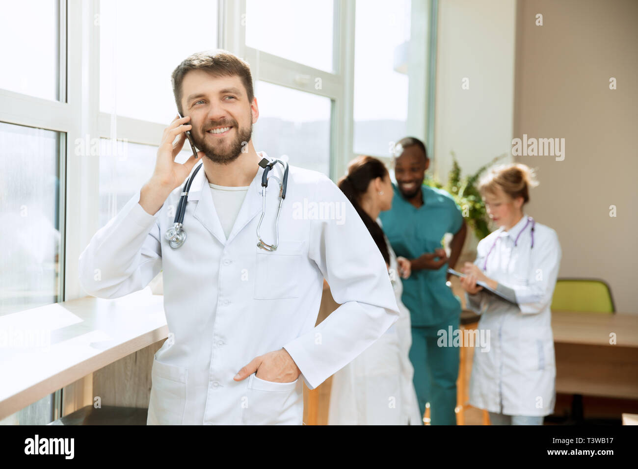 Healthcare people group. Professional caucasian male doctor with phone ...