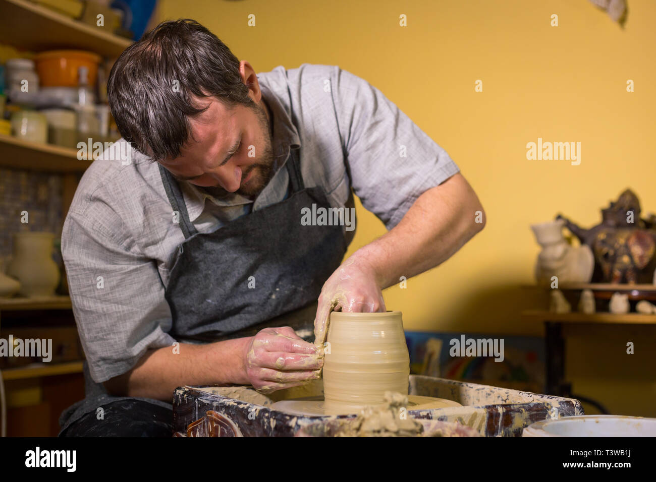 Professional male potter working with clay on potter's wheel Stock ...