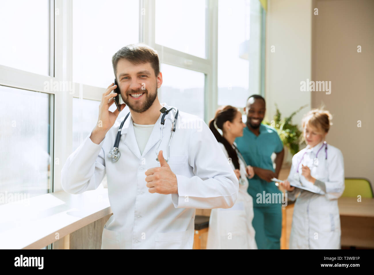 Healthcare people group. Professional caucasian male doctor with phone ...