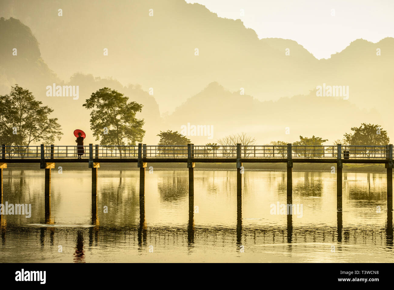 Mountains and bridge reflected in still lake, Hpa an, Kayin, Myanmar ...