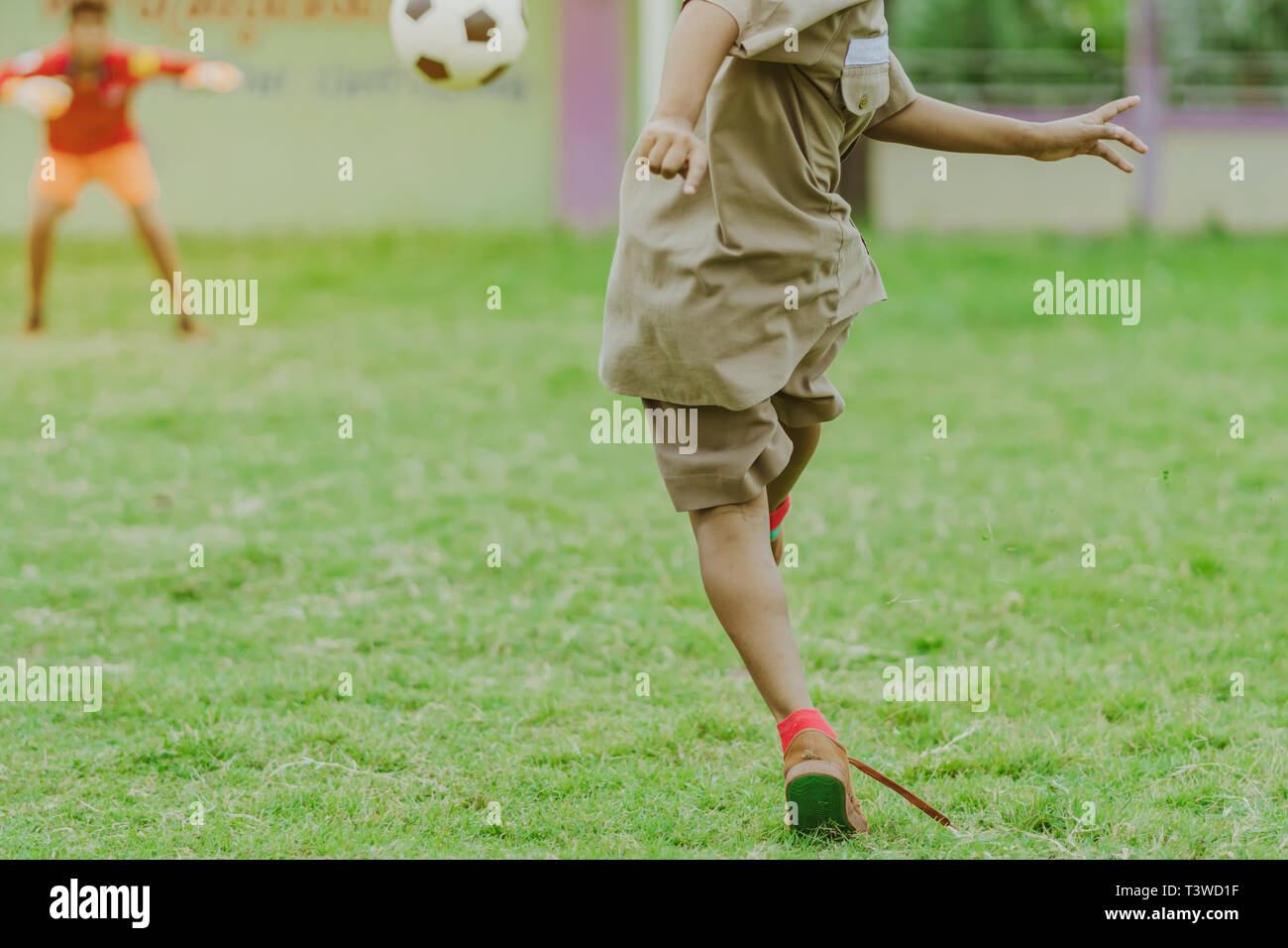 Kid kicking football asia hi-res stock photography and images - Alamy
