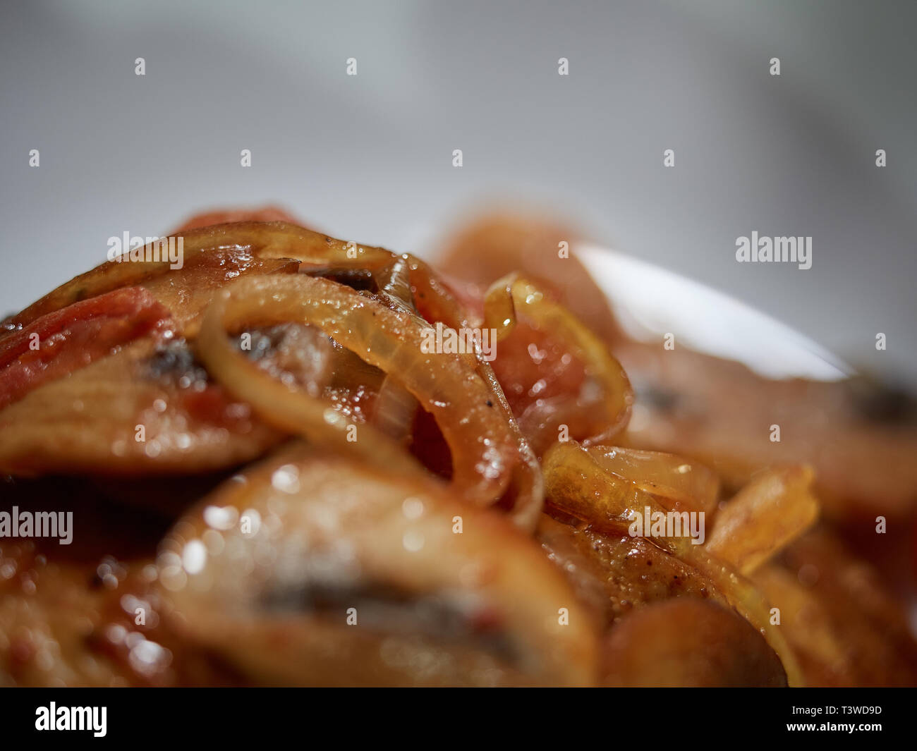 Small cuts of meat cooked along with fried mushrooms and onions are ...