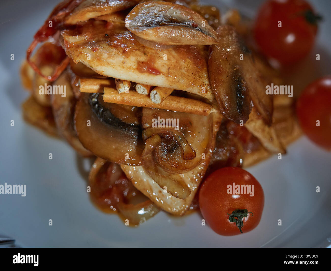 Small cuts of meat cooked along with fried mushrooms and onions are ...