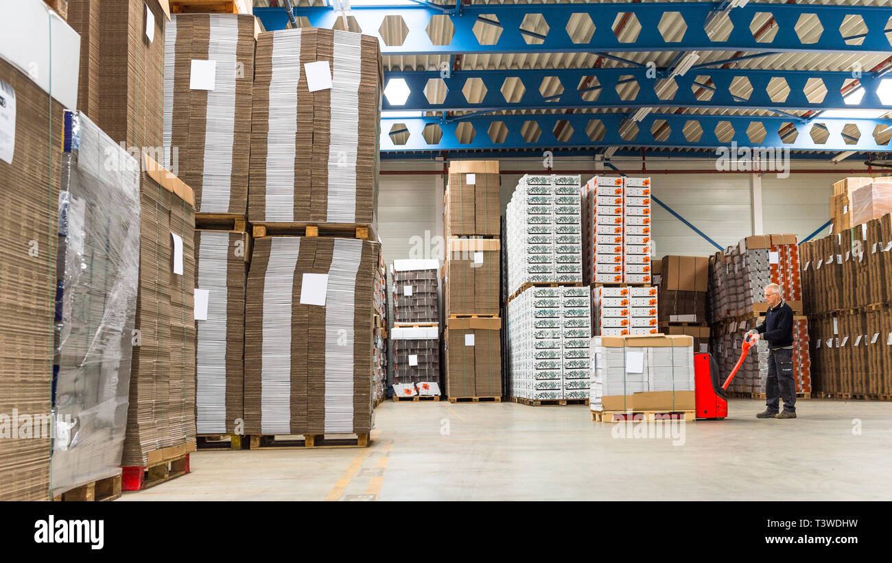 Caucasian worker pushing pallet on dolly in warehouse Stock Photo - Alamy