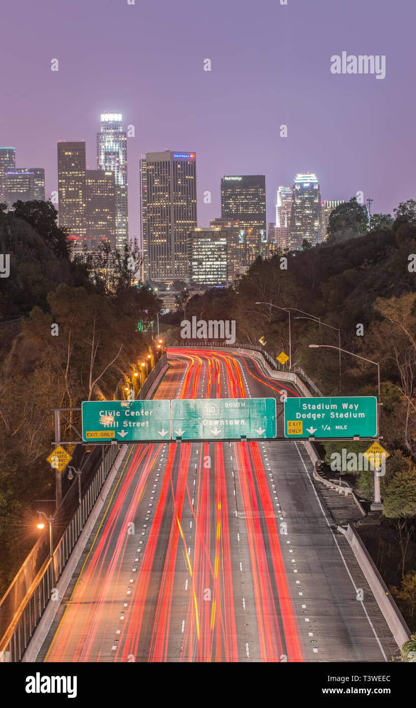 Los Angeles city skyline over busy highway illuminated at night ...