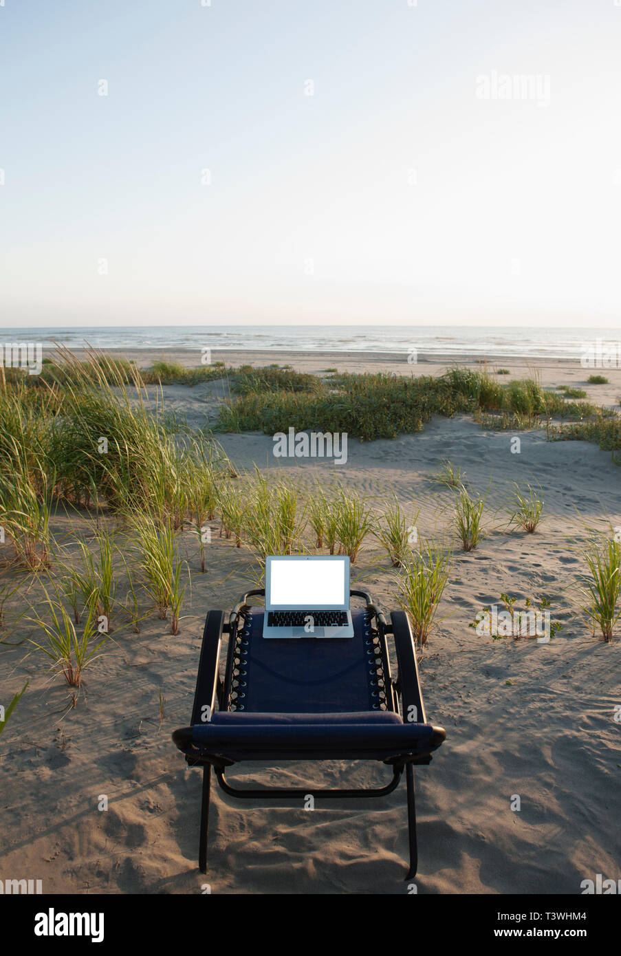 Laptop on deck chair overlooking beach Stock Photo - Alamy