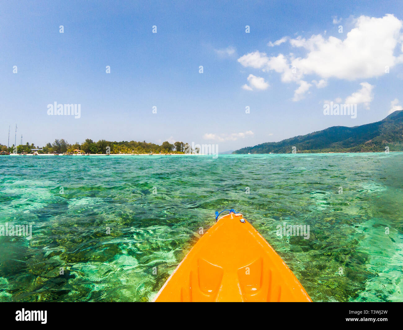 kayaking in crystal clear tropical waters - kayak heading to isolated ...