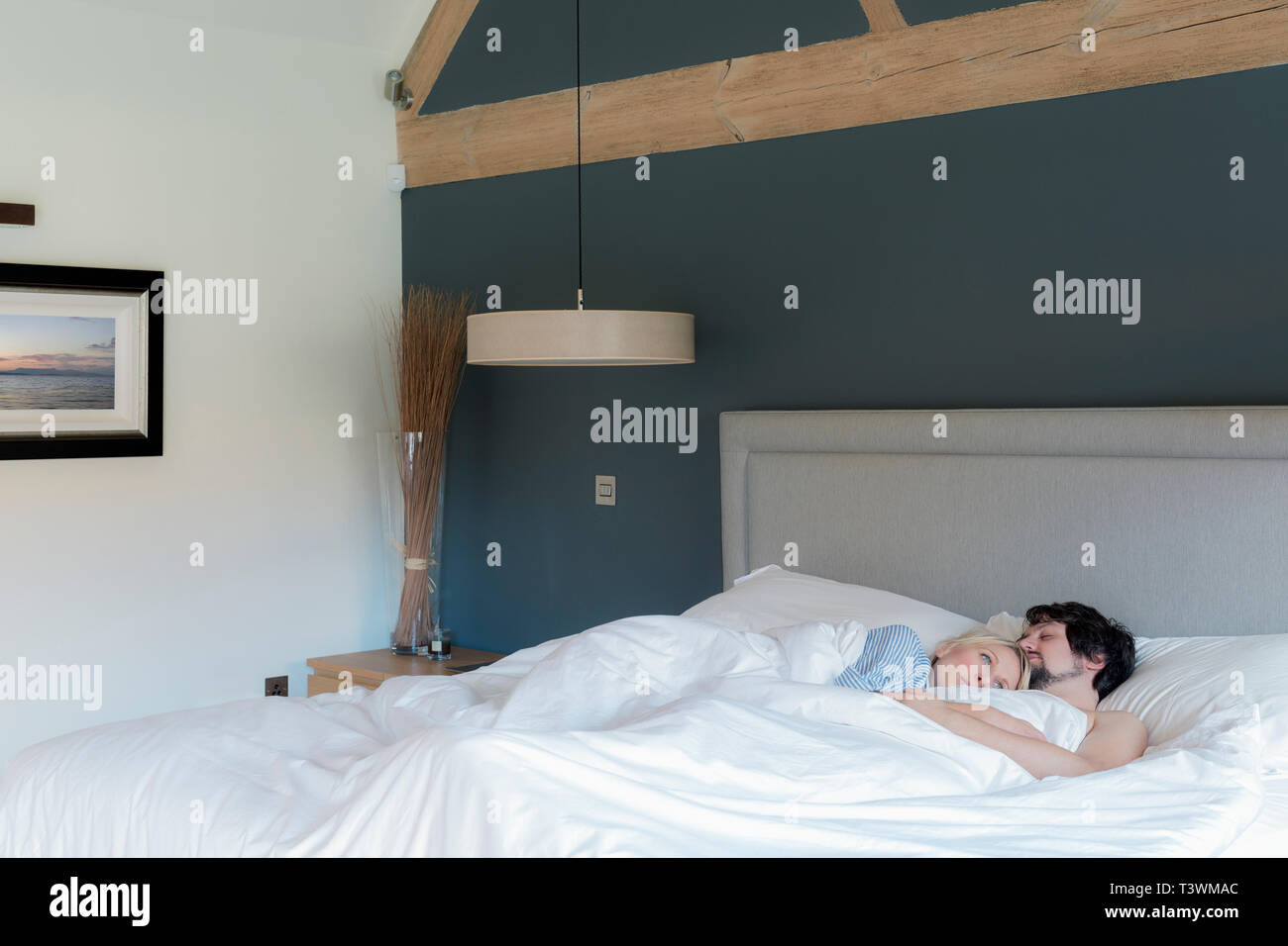 Caucasian couple laying in bed Stock Photo - Alamy