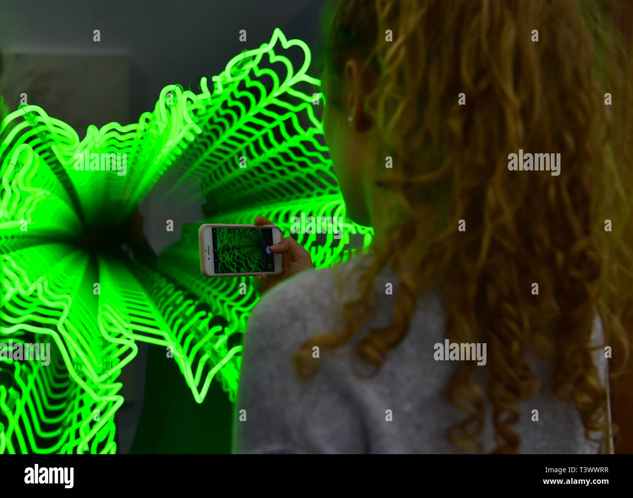 Cologne, Germany. 11th Apr, 2019. A visitor takes photos of an ...