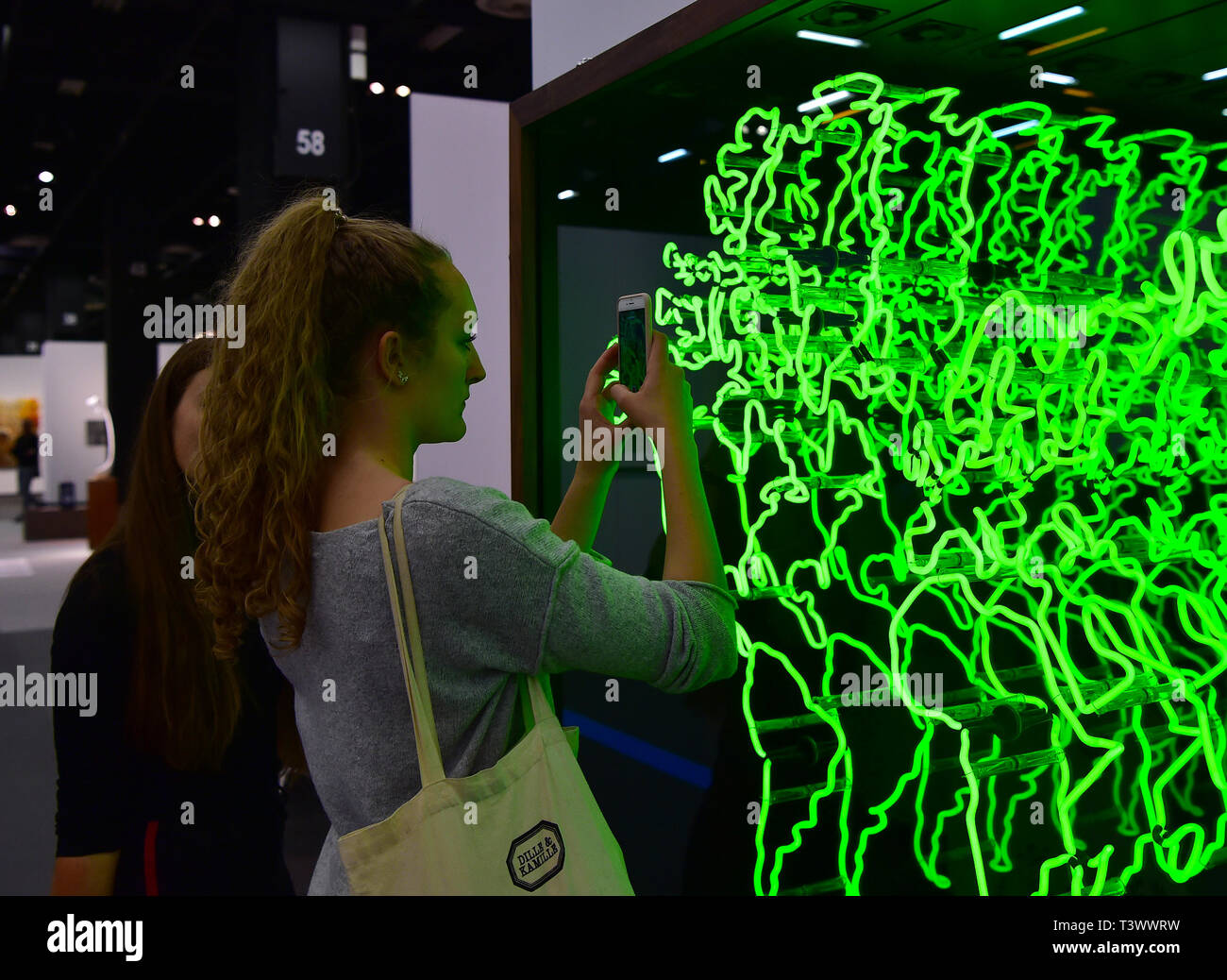 Cologne, Germany. 11th Apr, 2019. A visitor takes photos of an ...