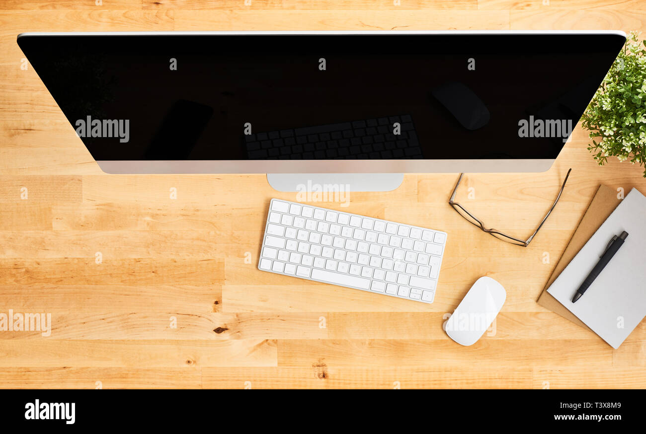Modern desktop computer. Top view of wooden office desk with large ...