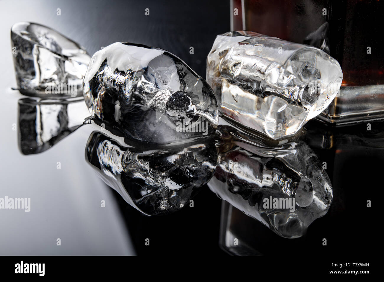 Tube shaped ice on a black table. Melted ice cube on the kitchen table ...